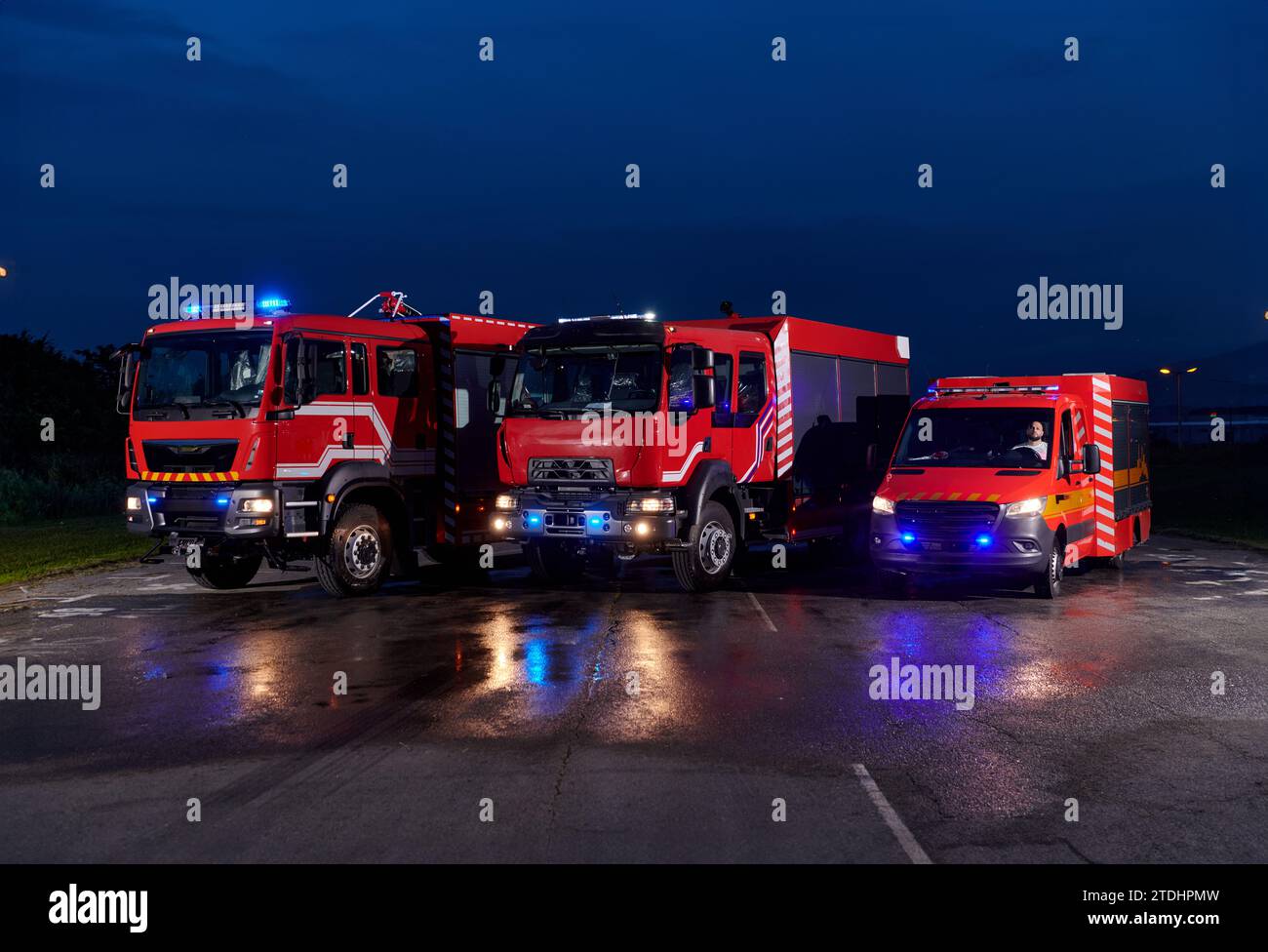 A pair of highly modern and quality fire trucks illuminate the night ...