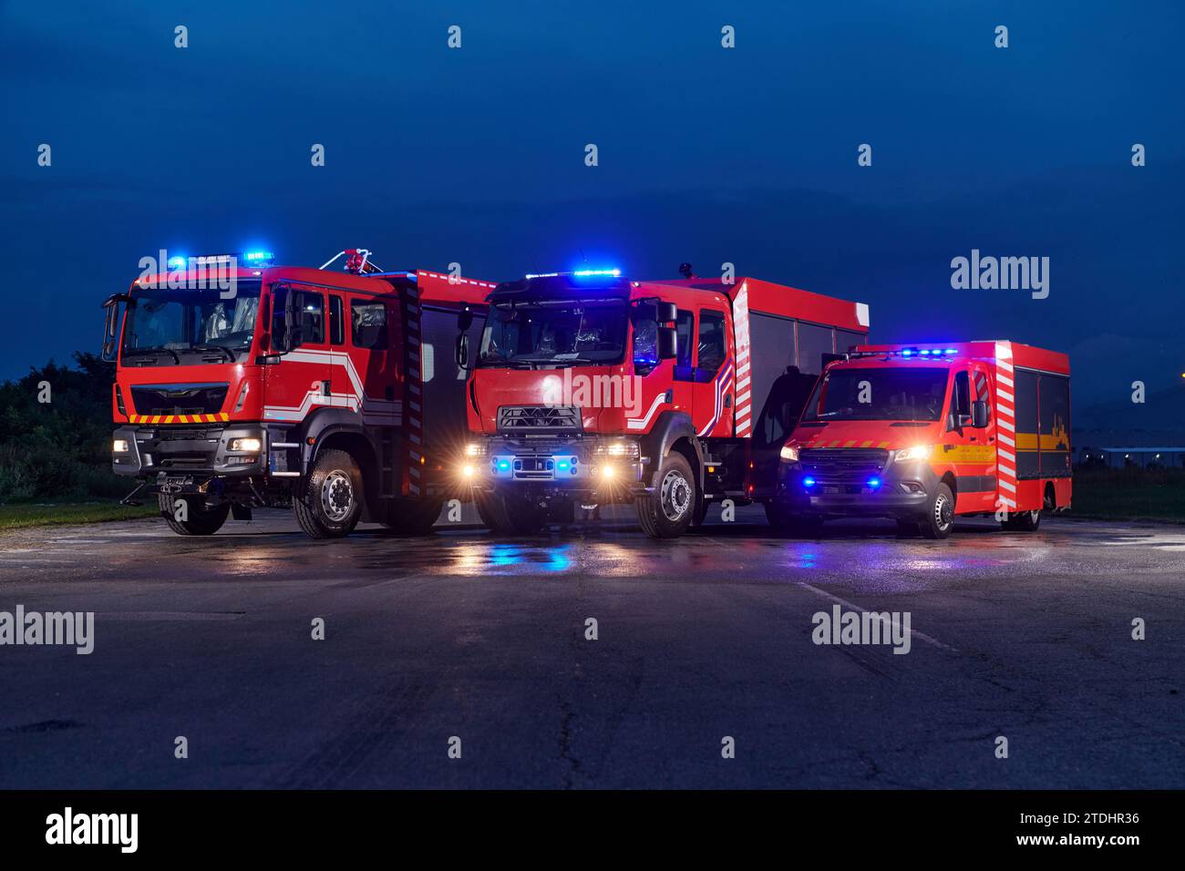 A pair of highly modern and quality fire trucks illuminate the night ...
