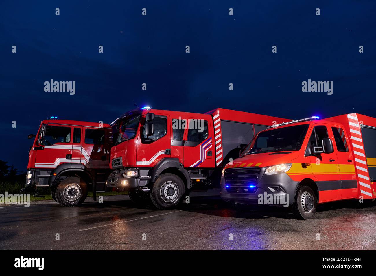 A pair of highly modern and quality fire trucks illuminate the night ...