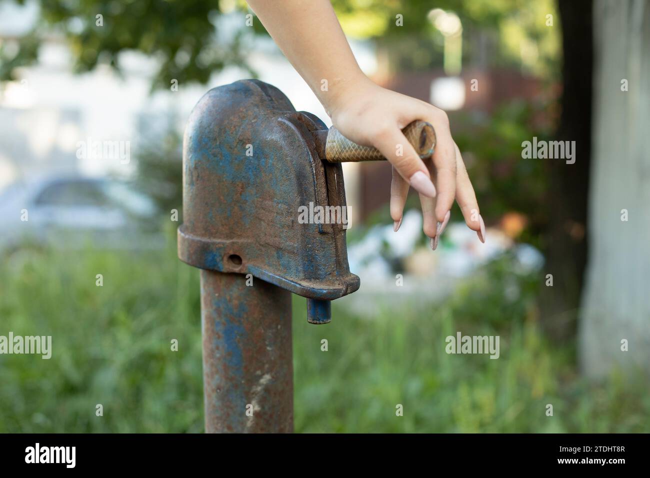 Water from well. Lever press. Girl presses handle of hydrant. Drinking ...