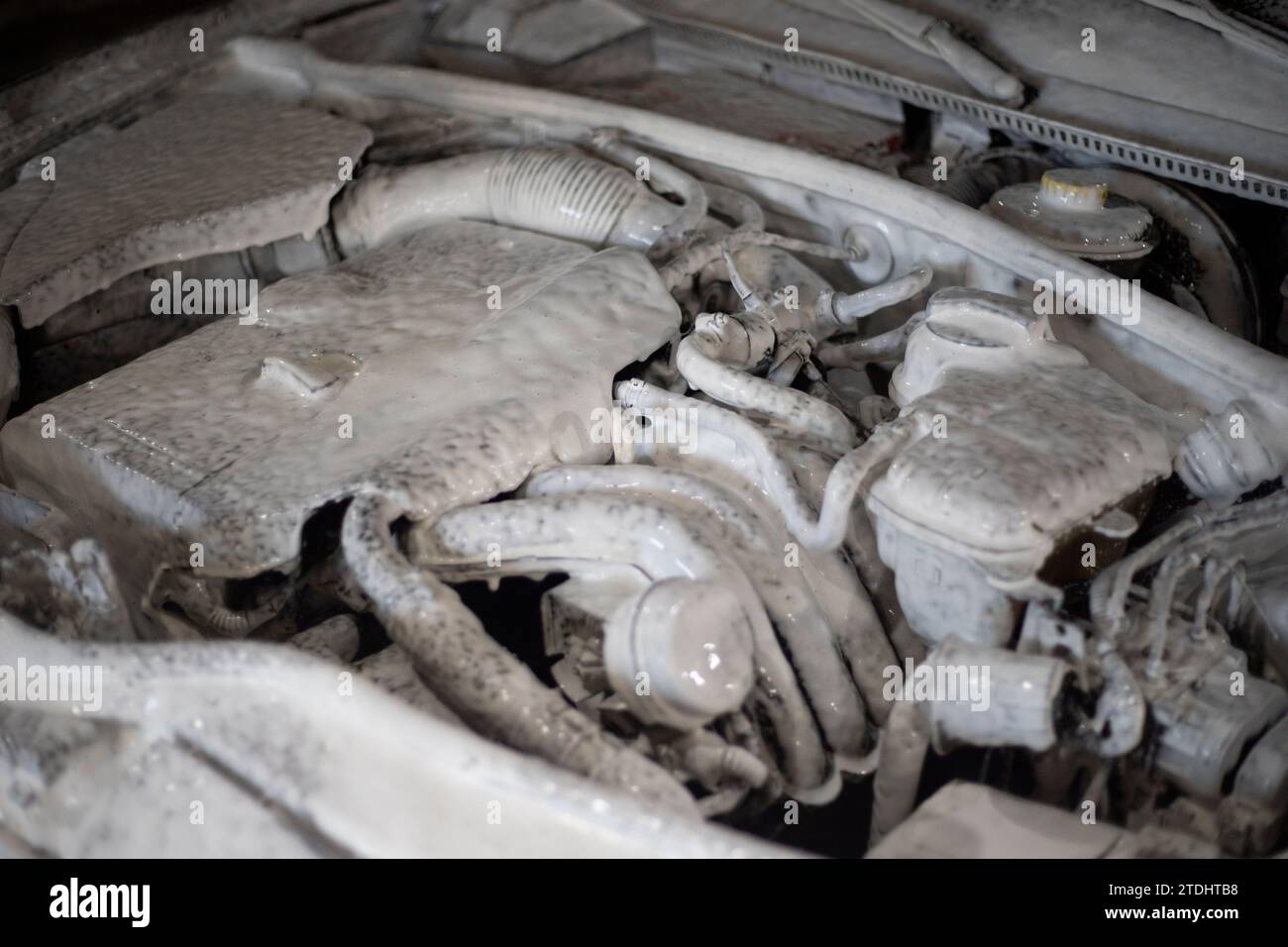 Soap scum on a car engine. Washing dirt off the engine. Car in a car ...