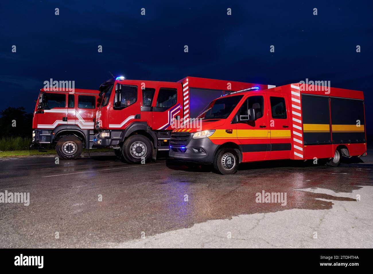 A pair of highly modern and quality fire trucks illuminate the night ...