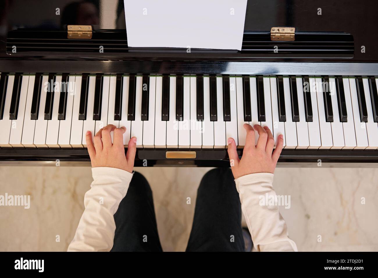 View from above of a child student, future musician pianist touching ...