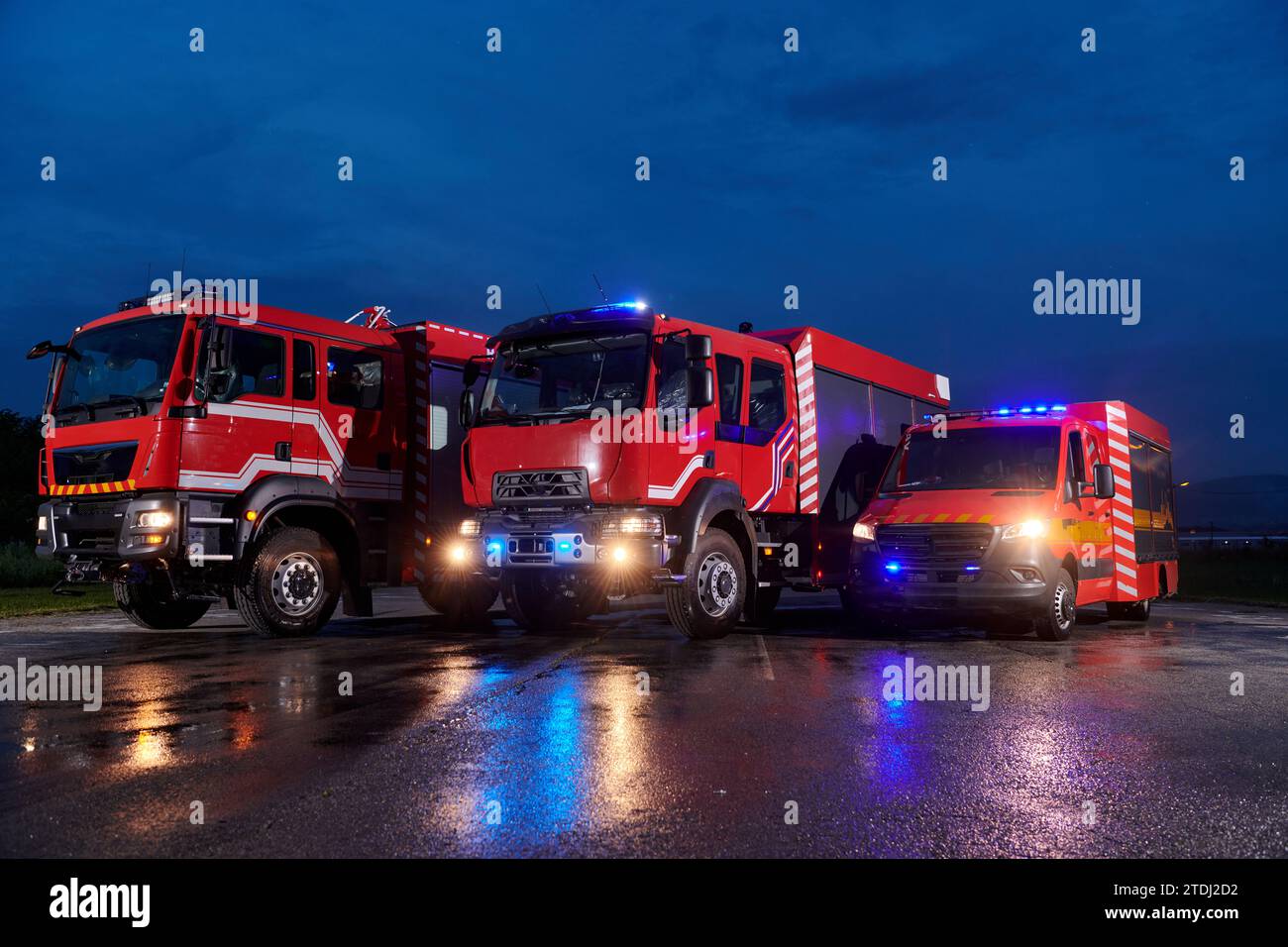 A pair of highly modern and quality fire trucks illuminate the night ...