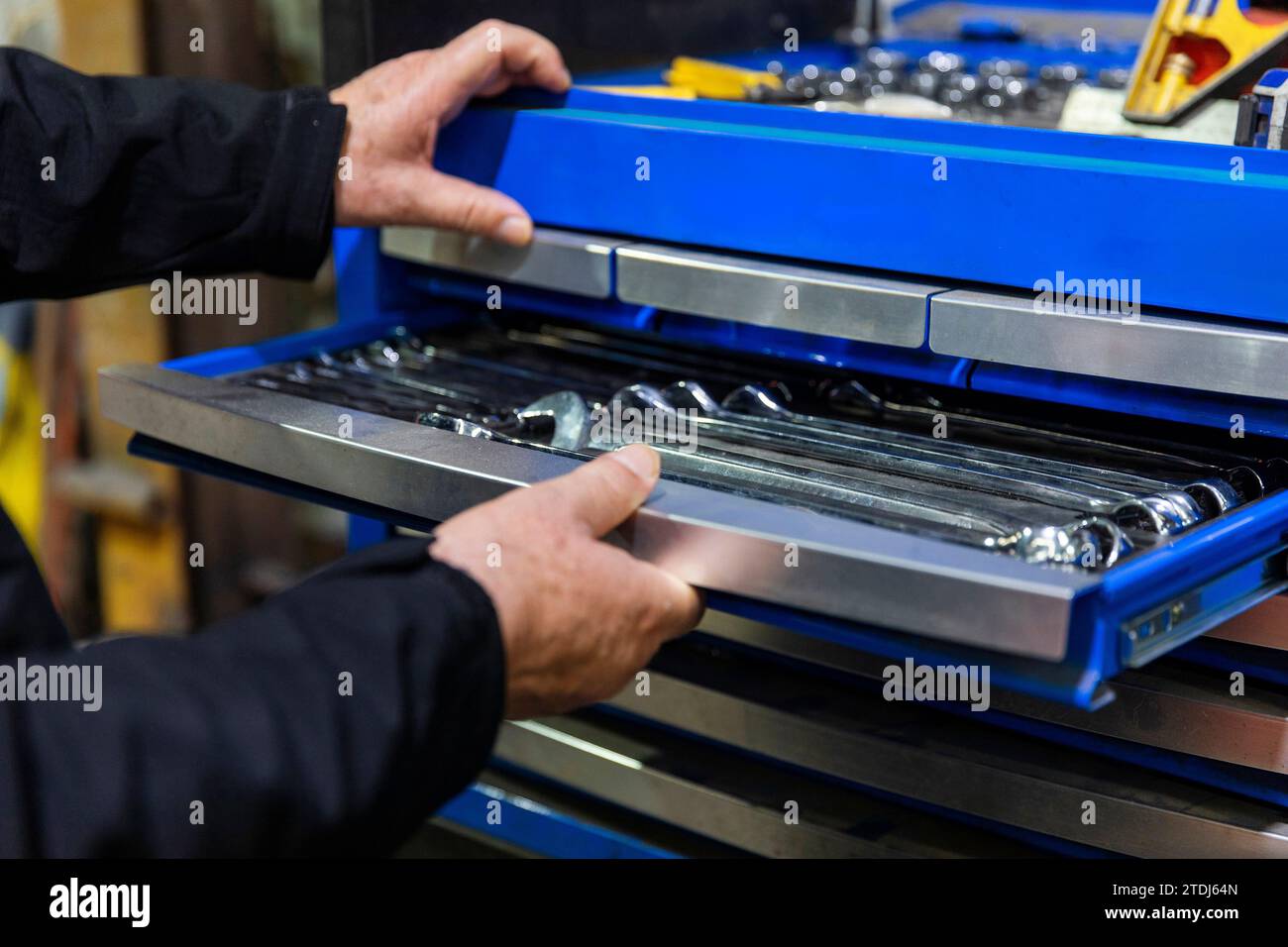 Mechanic searching through a toolbox, selecting the right tools for the ...