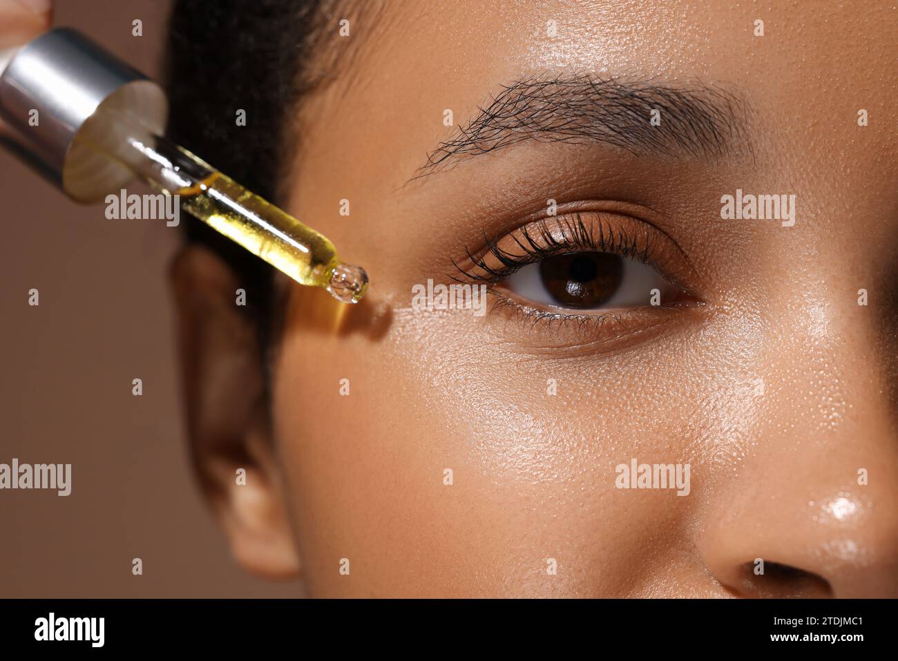 Woman applying serum onto her face, closeup Stock Photo - Alamy