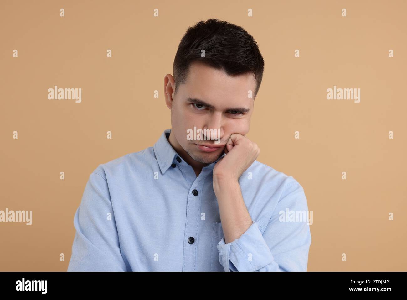 Portrait of resentful man on beige background Stock Photo - Alamy