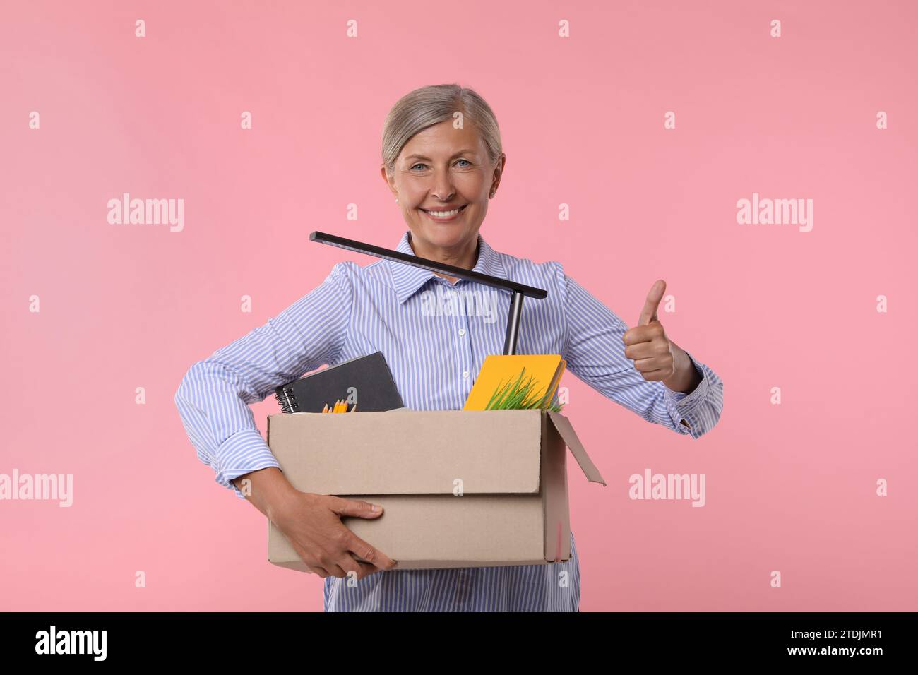 Happy unemployed senior woman with box of personal office belongings ...
