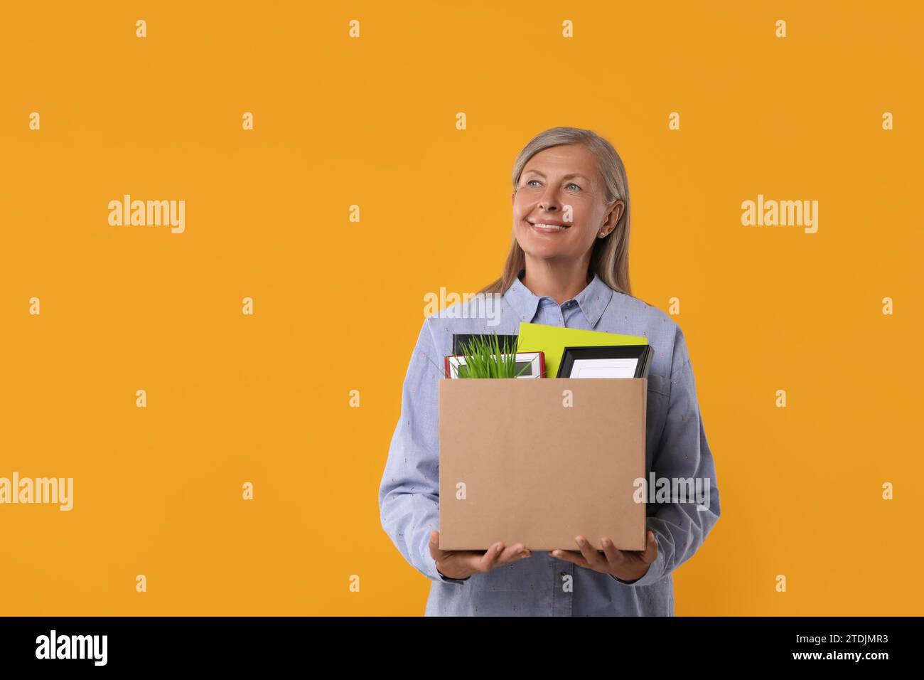 Happy unemployed senior woman with box of personal office belongings on ...