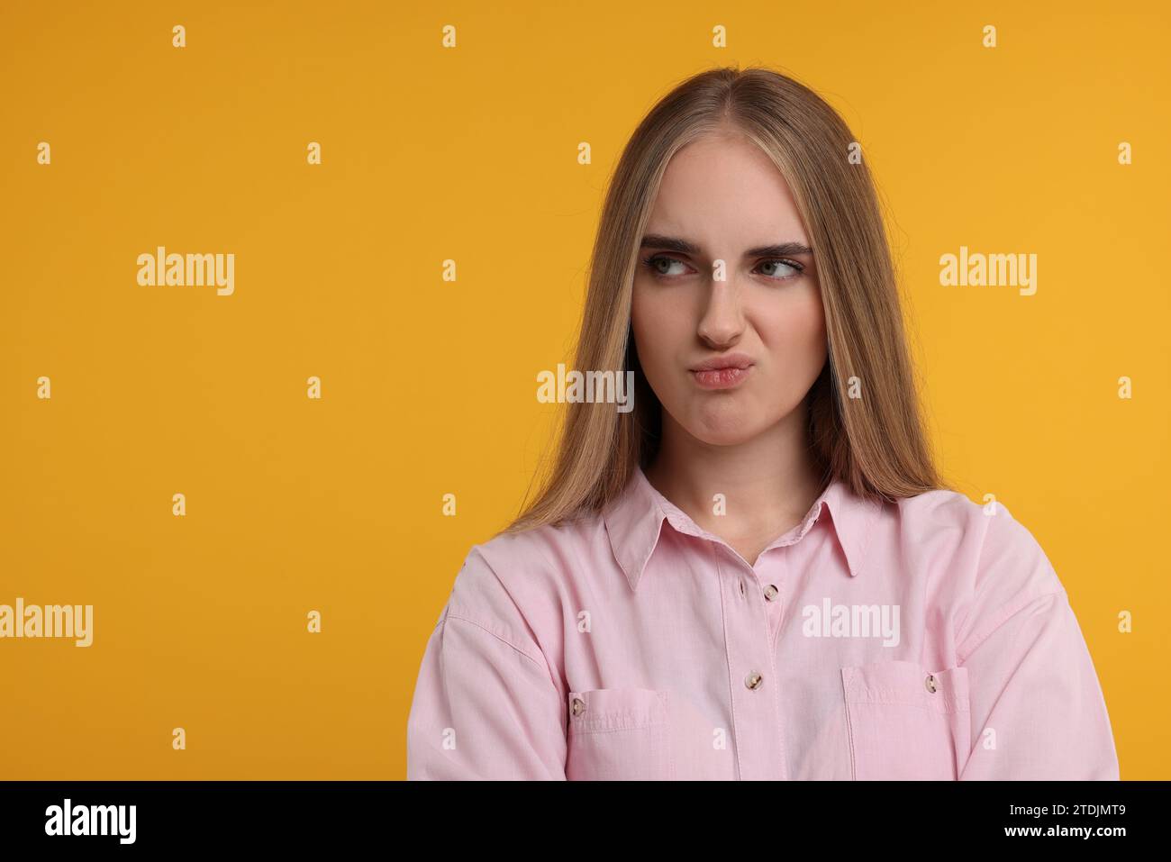 Resentful woman on orange background, space for text Stock Photo - Alamy