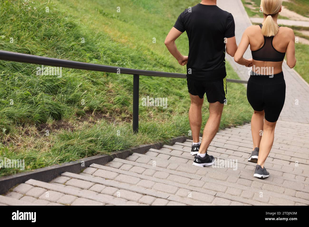 Healthy lifestyle. Couple running down stairs outdoors, back view Stock ...