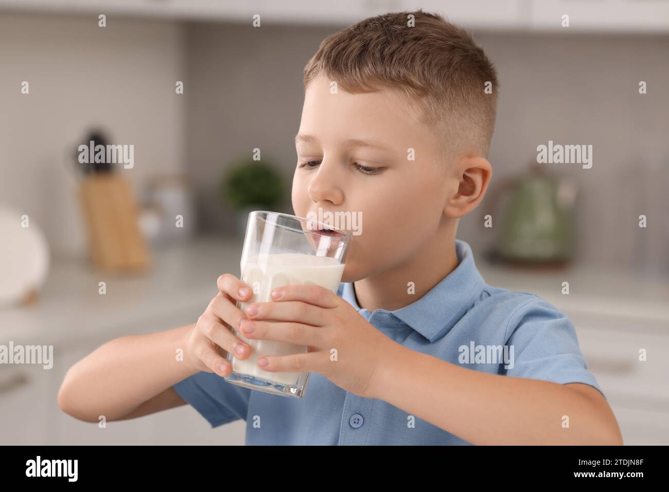 Cute boy drinking fresh milk from glass indoors Stock Photo - Alamy