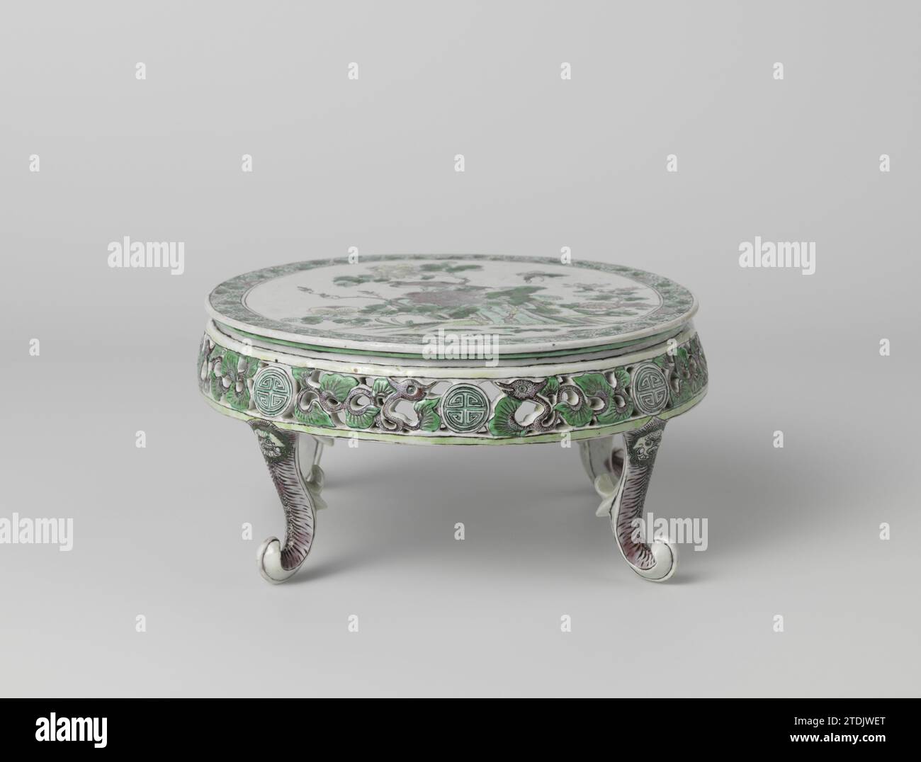 Round table with four scroll legs with a bird on a rock with flowering ...