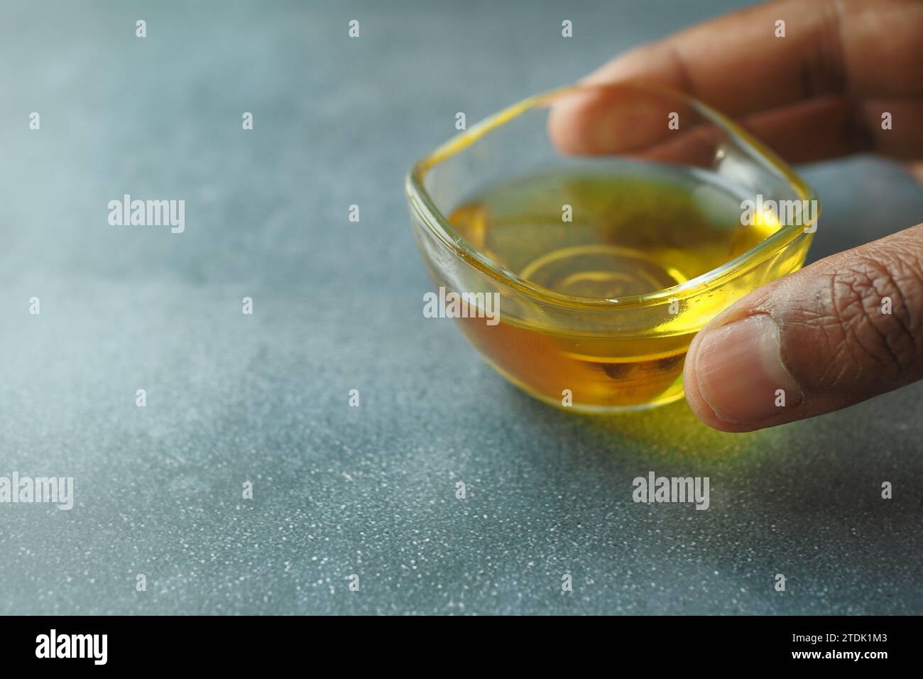 hand holding a small container of olive oil Stock Photo - Alamy