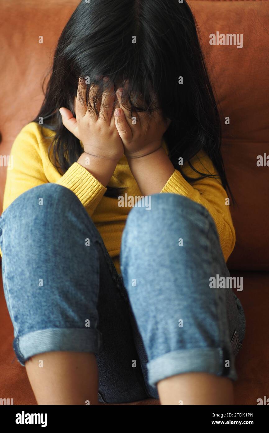 a upset child girl cover her face with hand Stock Photo - Alamy
