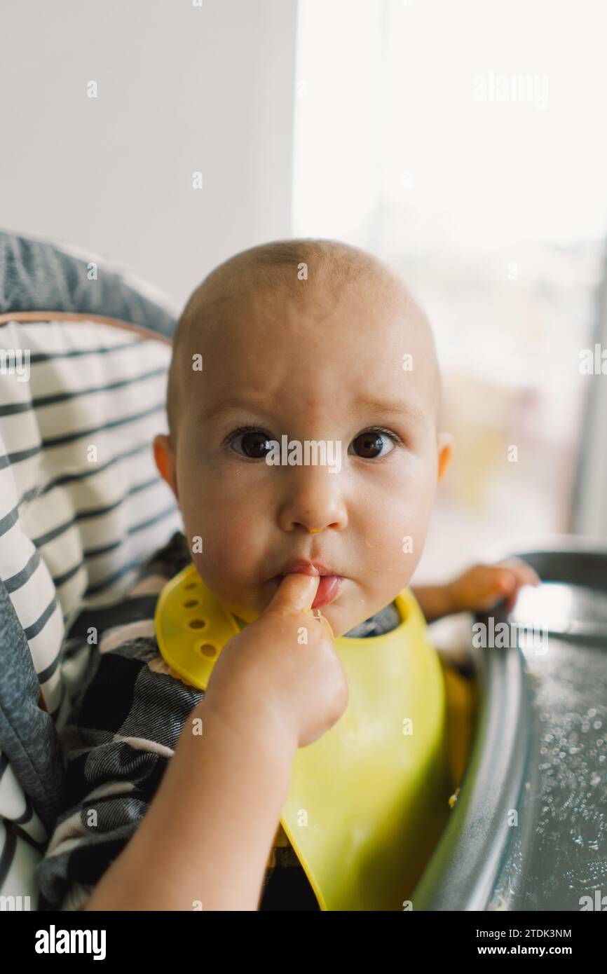 Little child with solid nutrition. Baby girl eating food and mix ...