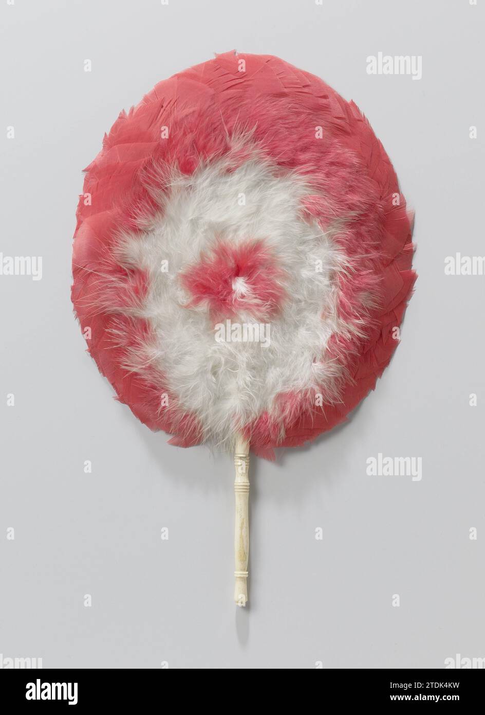 Sticks, with oval leaf of pink/red and white feathers on a sliced ivory ...