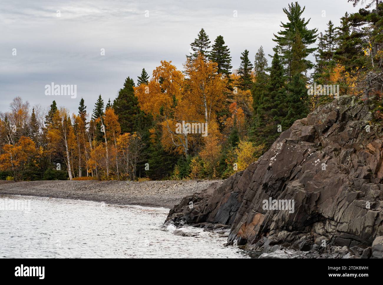 Trees with fall foliage along the rocky shoreline of Lake Superior on a ...