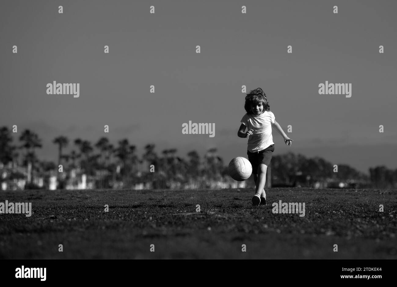 Boy child playing football on football field. Kid playing soccer. Kids ...