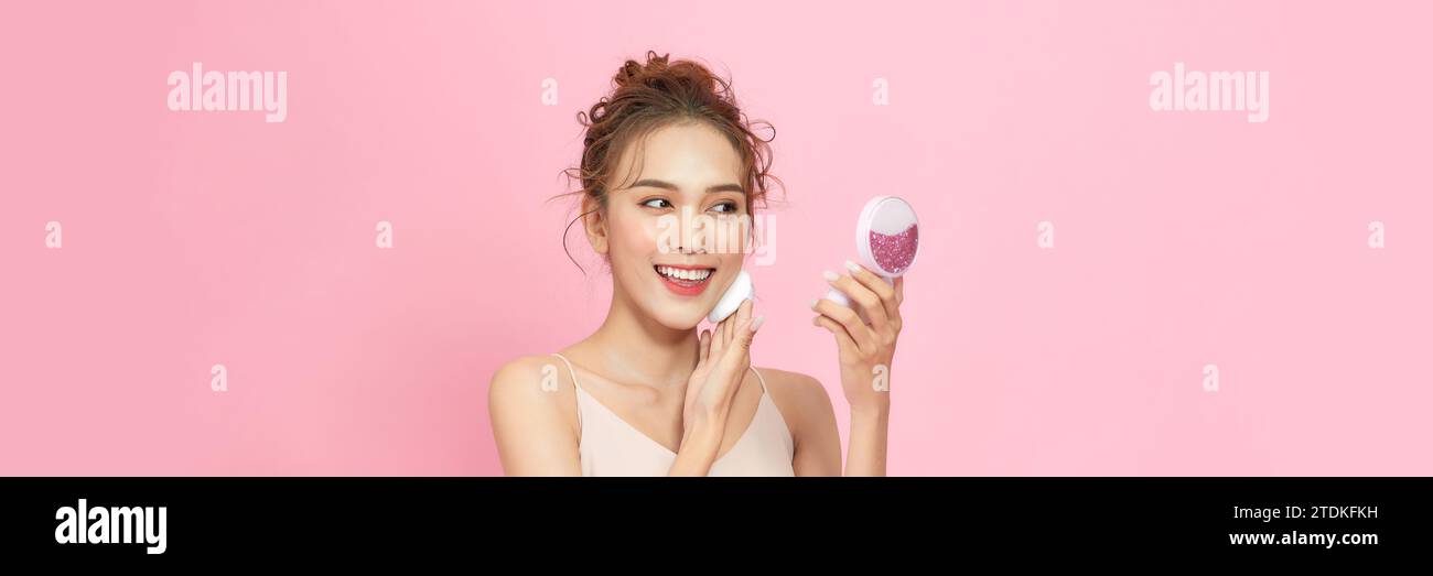 Portrait of beautiful asian woman applying powder puff at cheek makeup ...