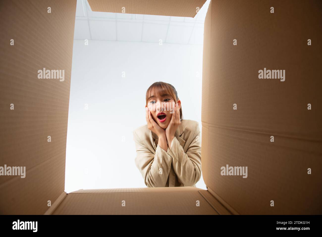 The surprised woman opening box and looking inside Stock Photo - Alamy
