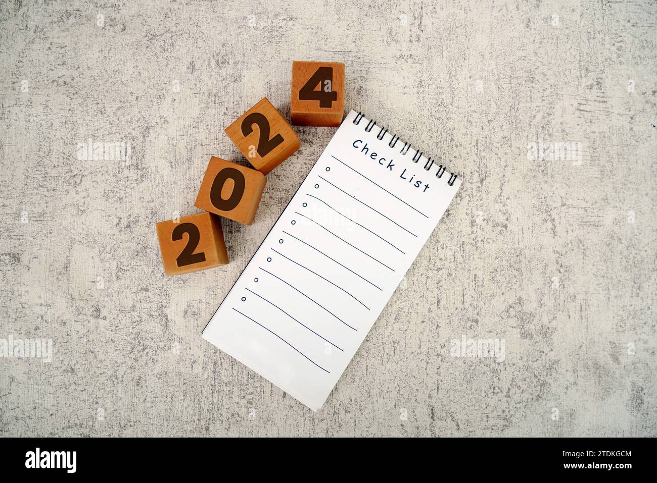 Wooden cubes with 2024 text and blank notebook paper on a brick wall ...