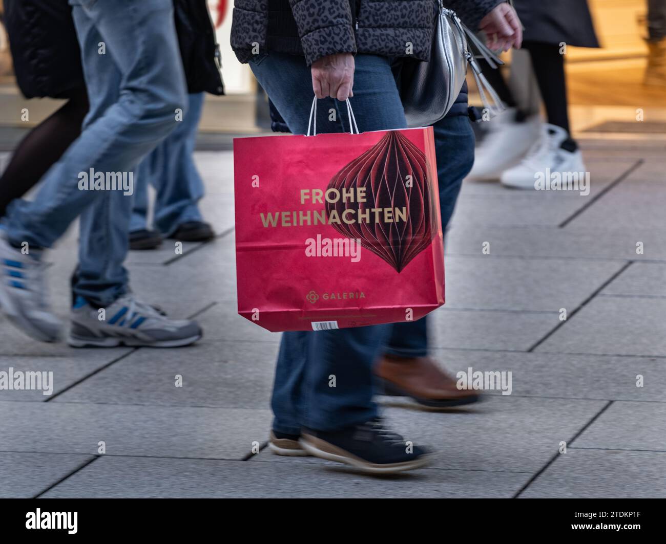 13 December 2023, Hesse, Frankfurt/Main: A passer-by carries a ...