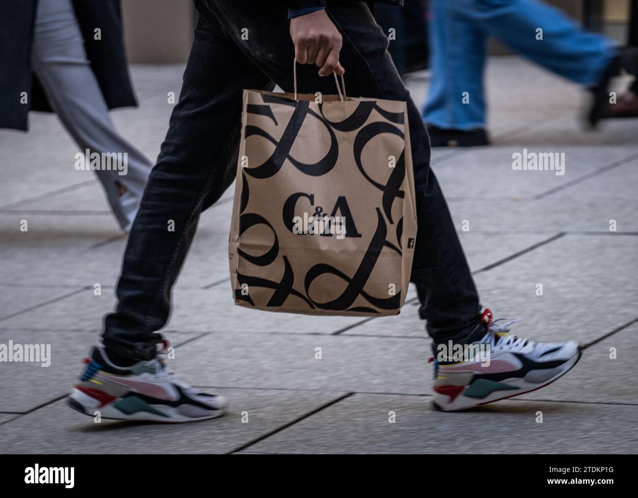 13 December 2023, Hesse, Frankfurt/Main: A passer-by carries a C&A bag ...