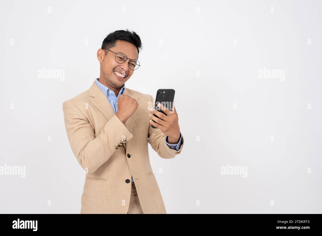 An excited and happy millennial Asian businessman is looking at his ...