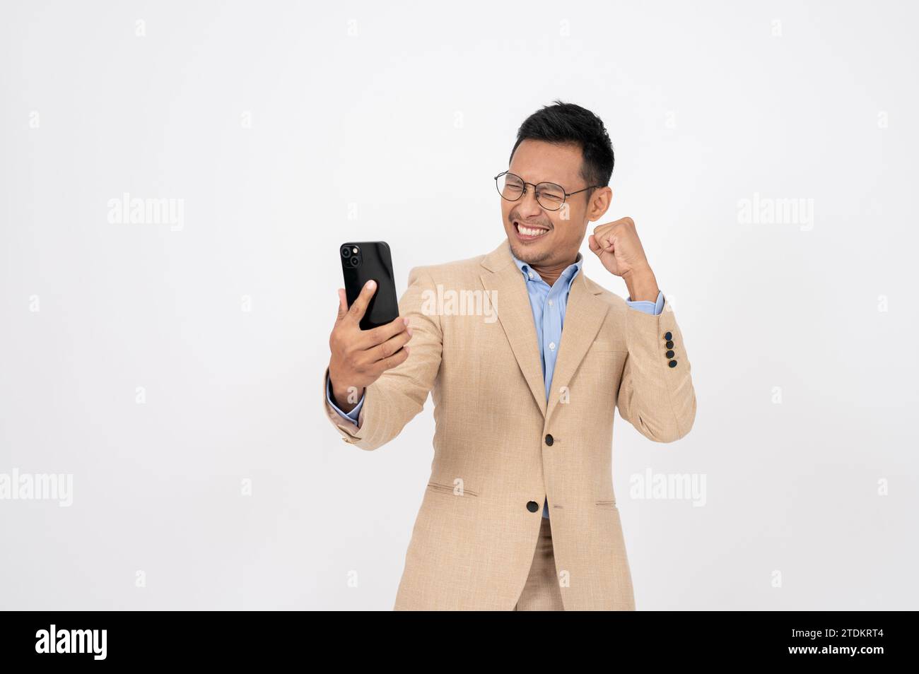 An excited and happy millennial Asian businessman is looking at his ...