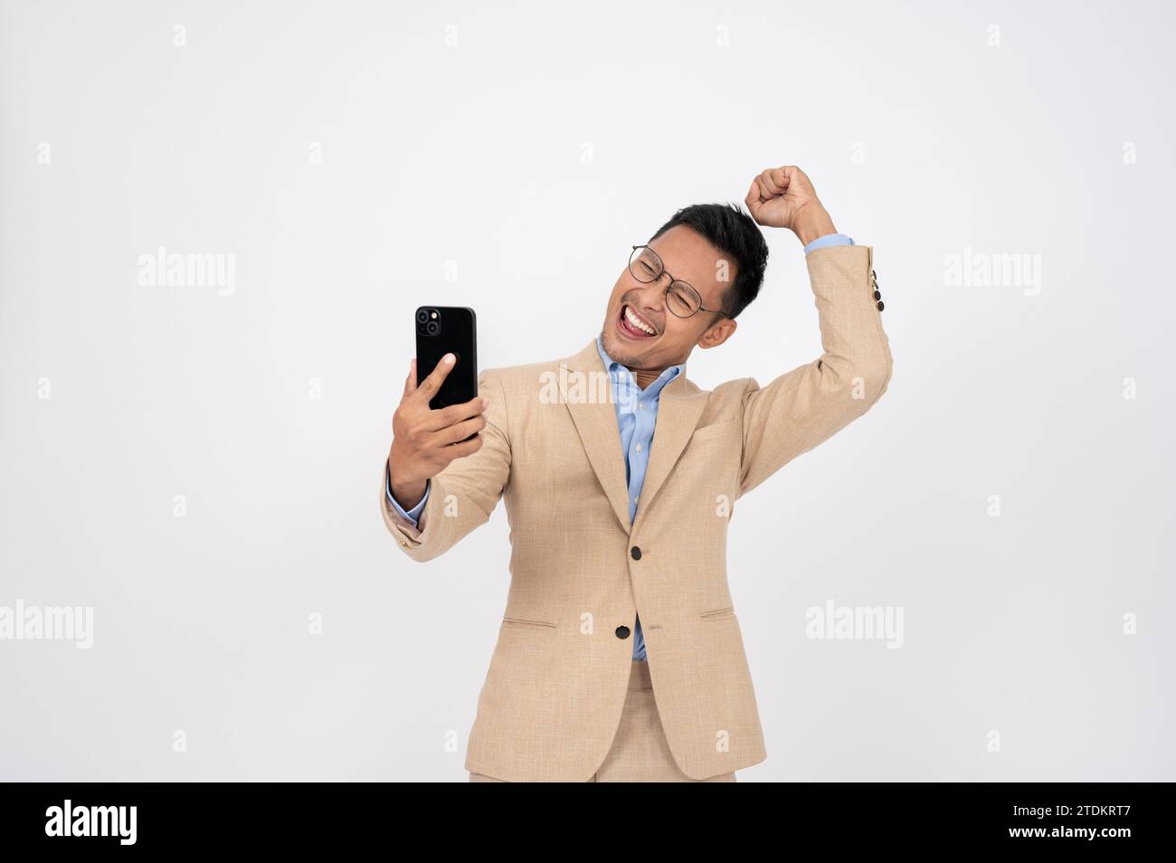 An excited and happy millennial Asian businessman is looking at his ...