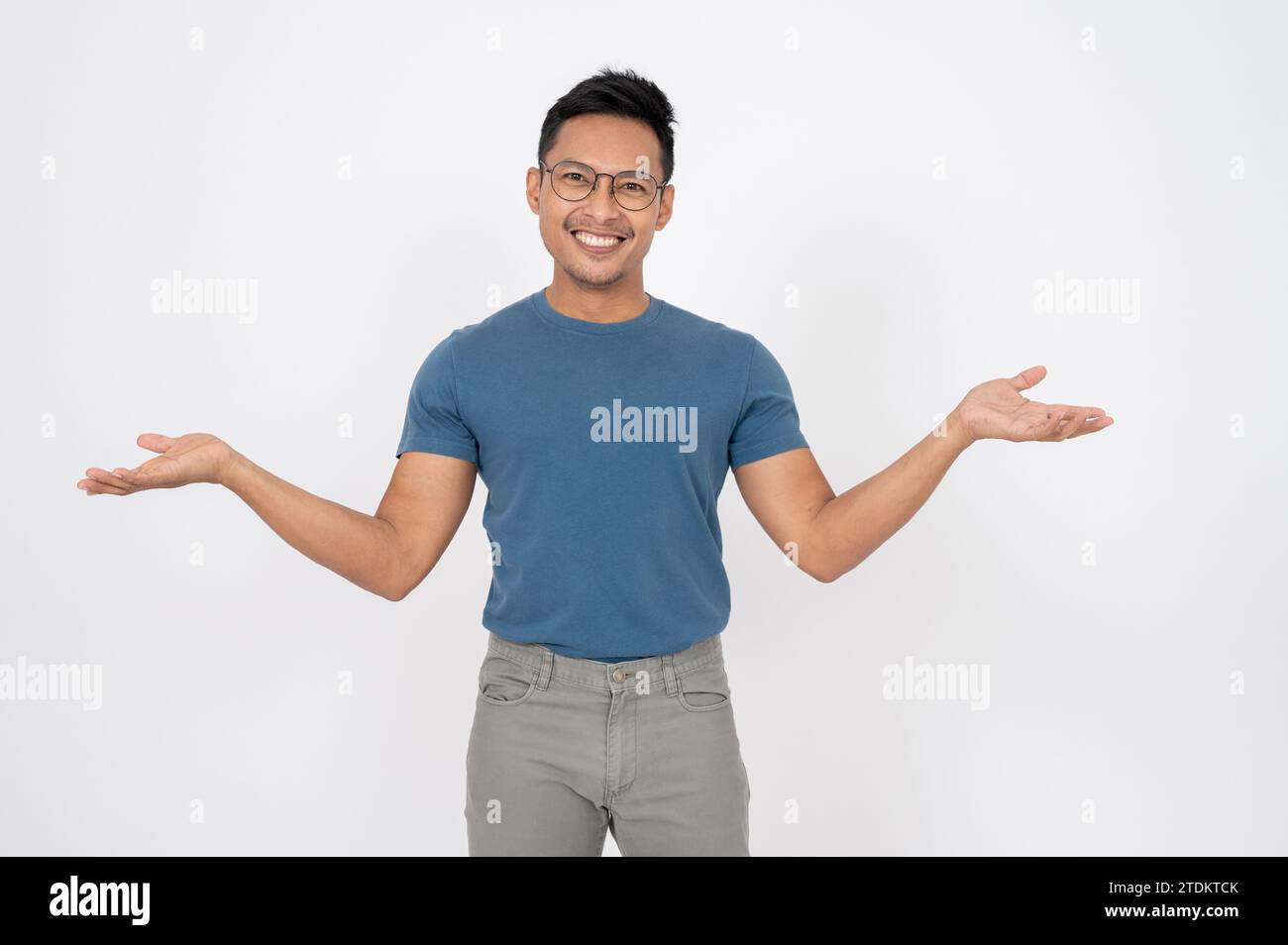 A positive Asian man in casual clothes is opening his palm widely ...