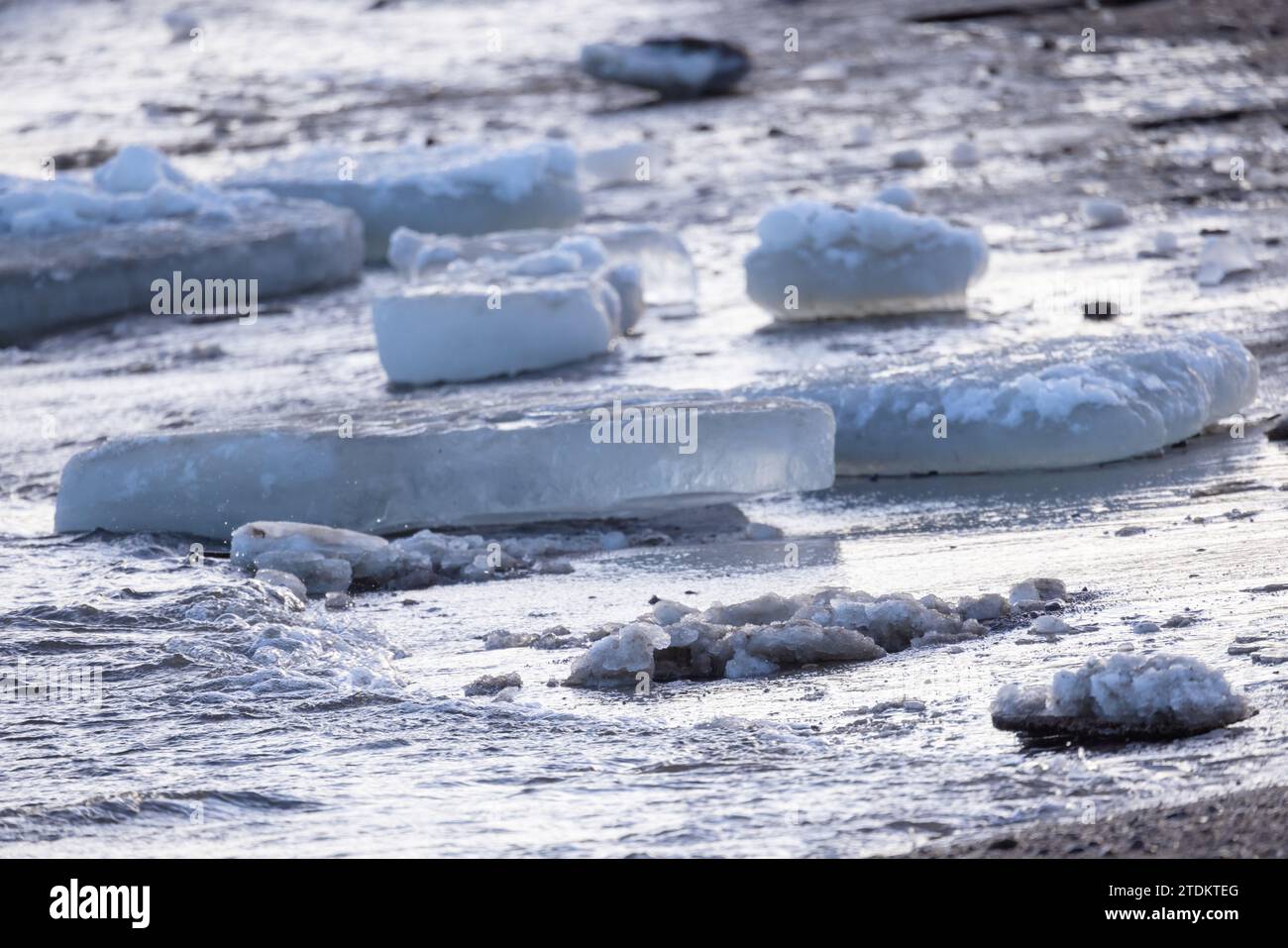 Melting ice floes lay on the coast of Baltic Sea on a daytime, natural ...
