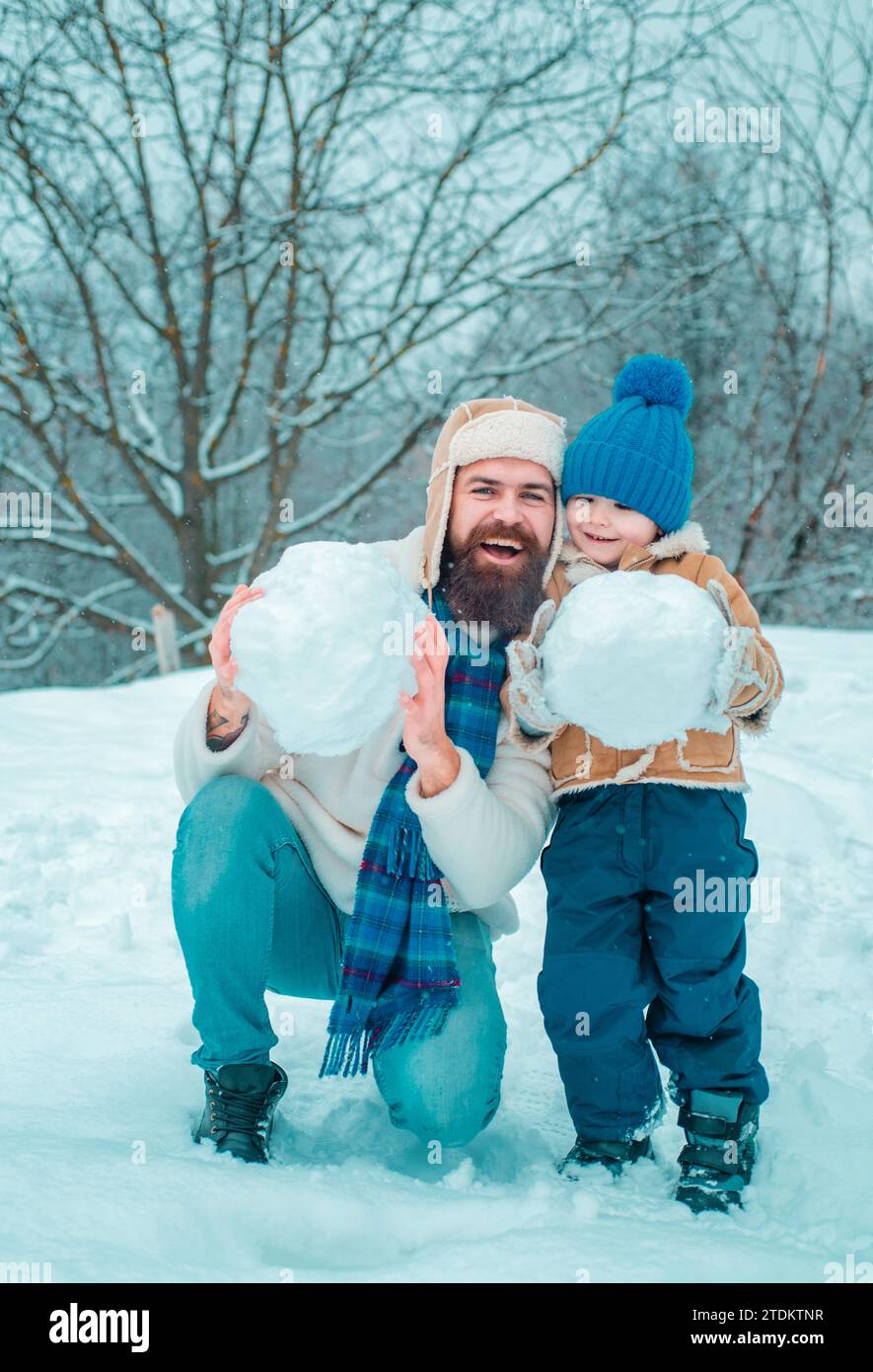 Best winter game for happy family. Happy father and son making snowman ...