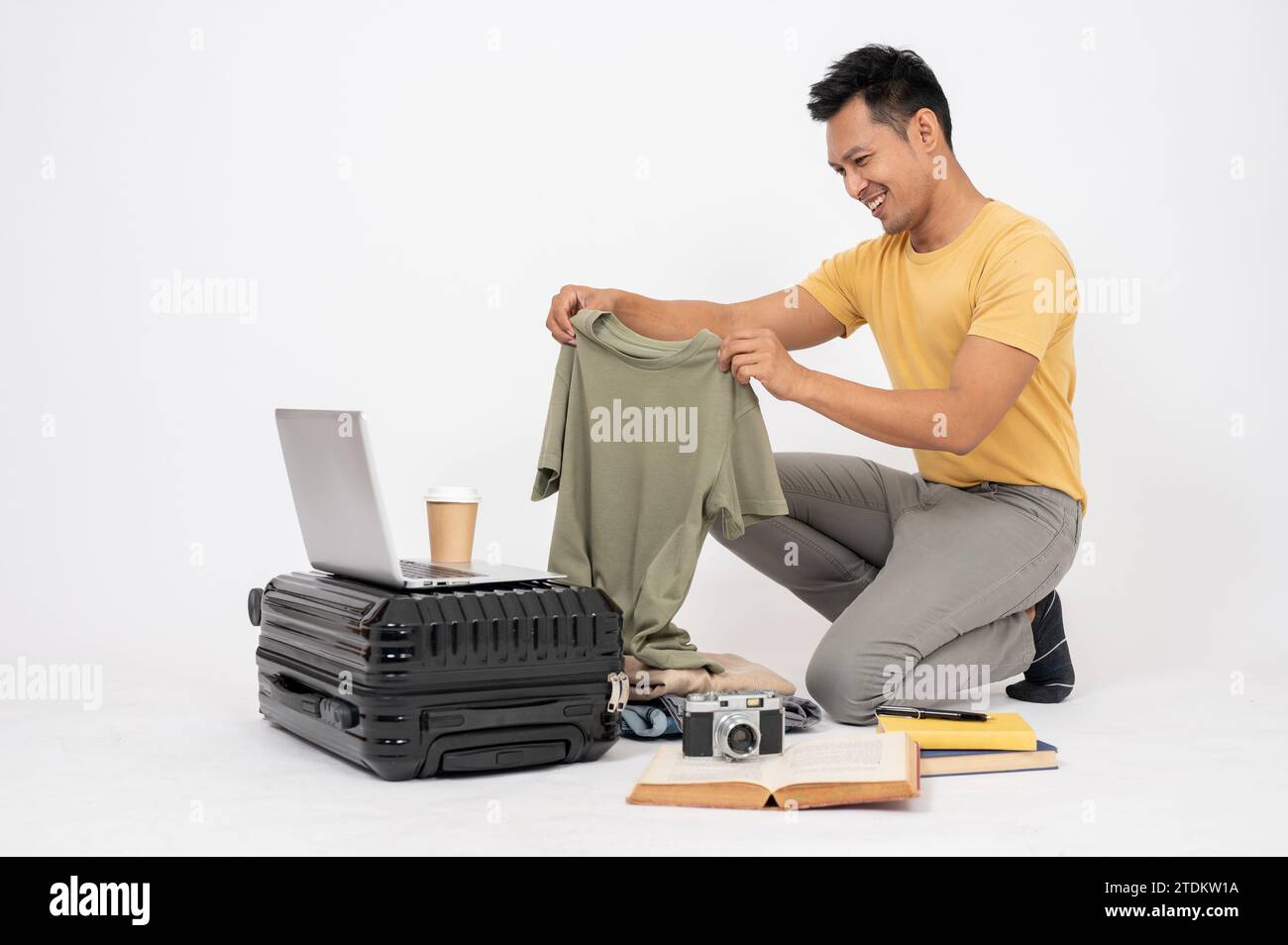 A happy, handsome Asian man is excited for his holiday trip, packing ...