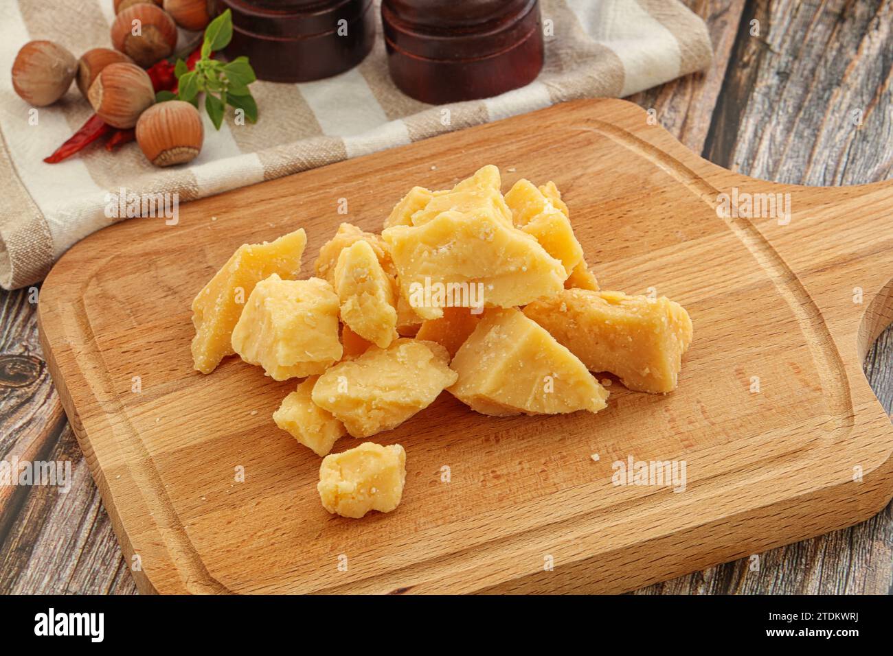 Crushed hard parmesan cheese pieces over board Stock Photo - Alamy