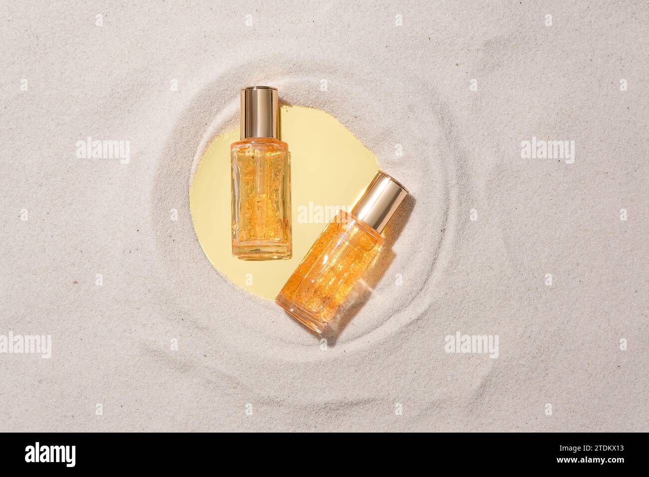 Two transparent serum bottles with yellow essence particles inside ...