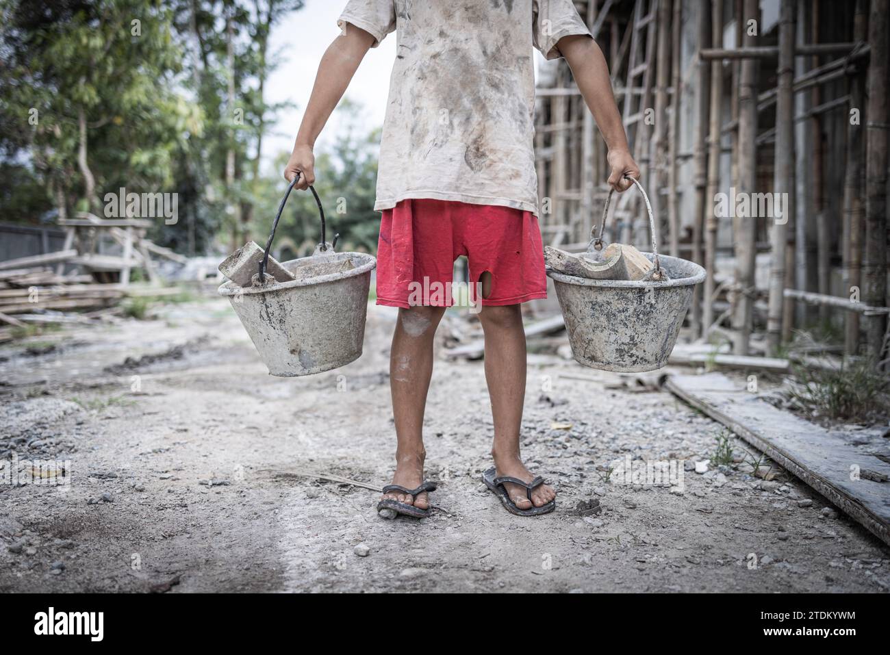 Children forced to work hard at construction site, child labor concept ...
