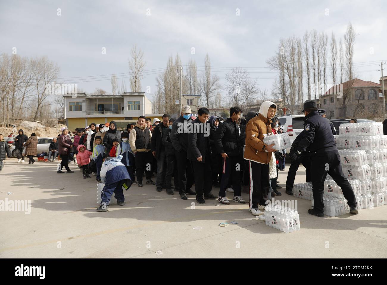 Linxia, China. 19 December, 2023. People receive bottled water at a ...