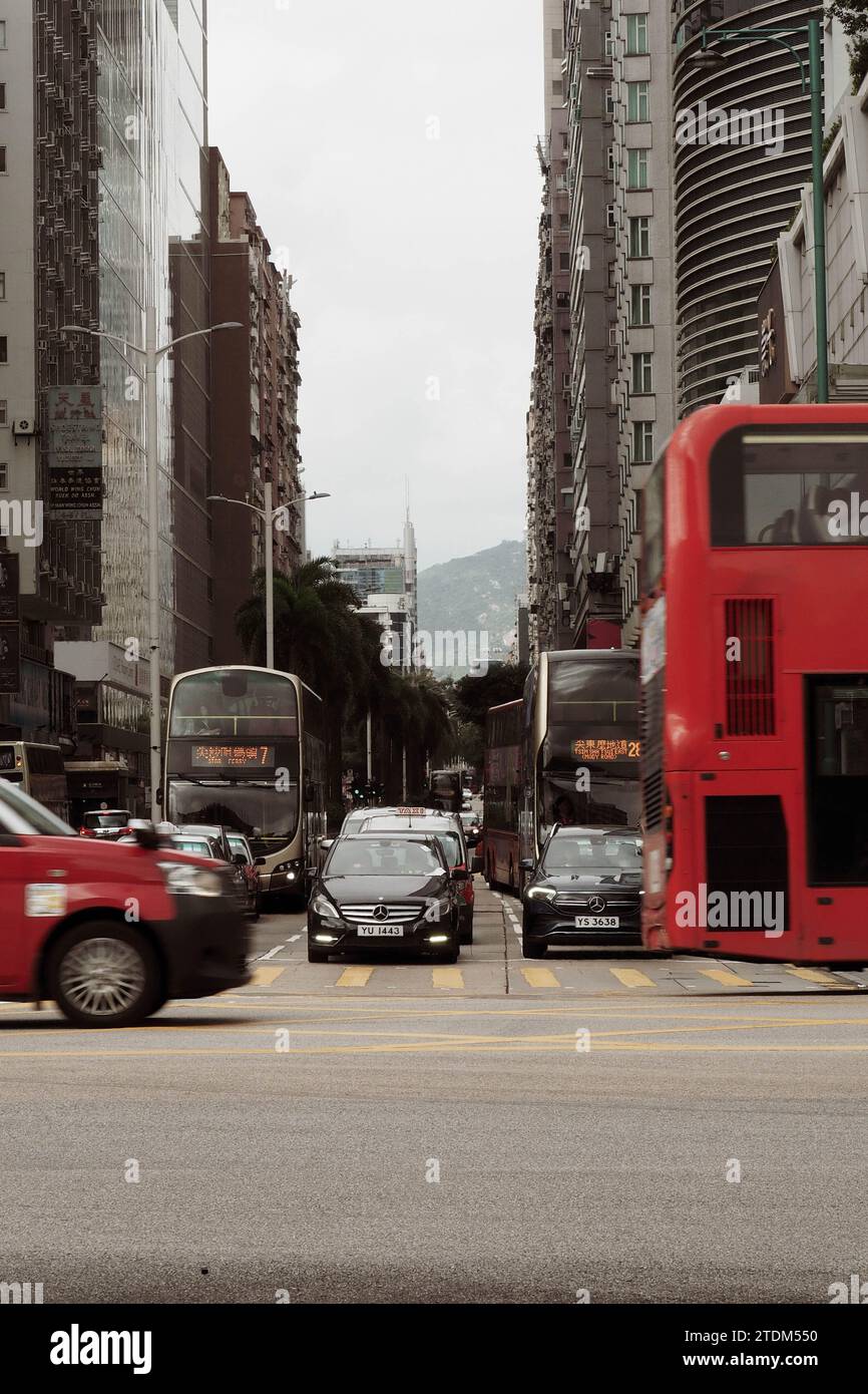 A busy intersection in Hong Kong with a Hong Kong red taxi and bus ...