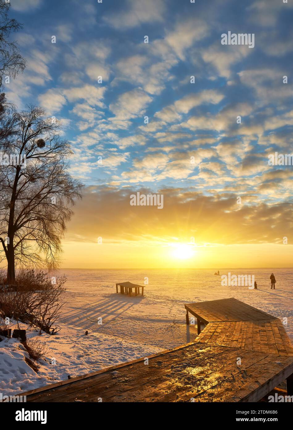 A breathtaking winter scene with a tranquil frozen lake. As the sun ...