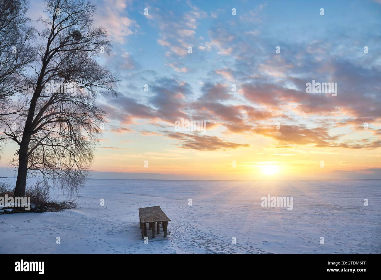 A breathtaking winter scene with a tranquil frozen lake. As the sun ...