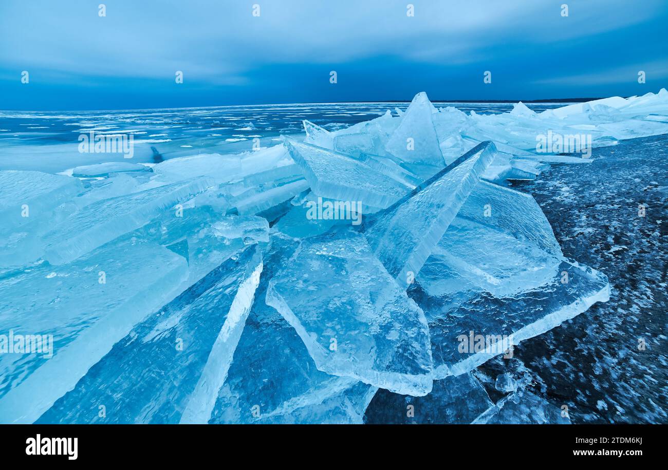 A striking winter view with a crystal-clear blue ice sheet gently ...