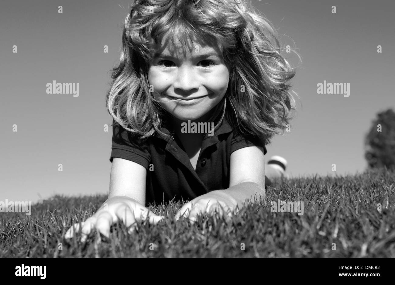 Portraits of happy kids playing and laying on grass outdoors in summer ...