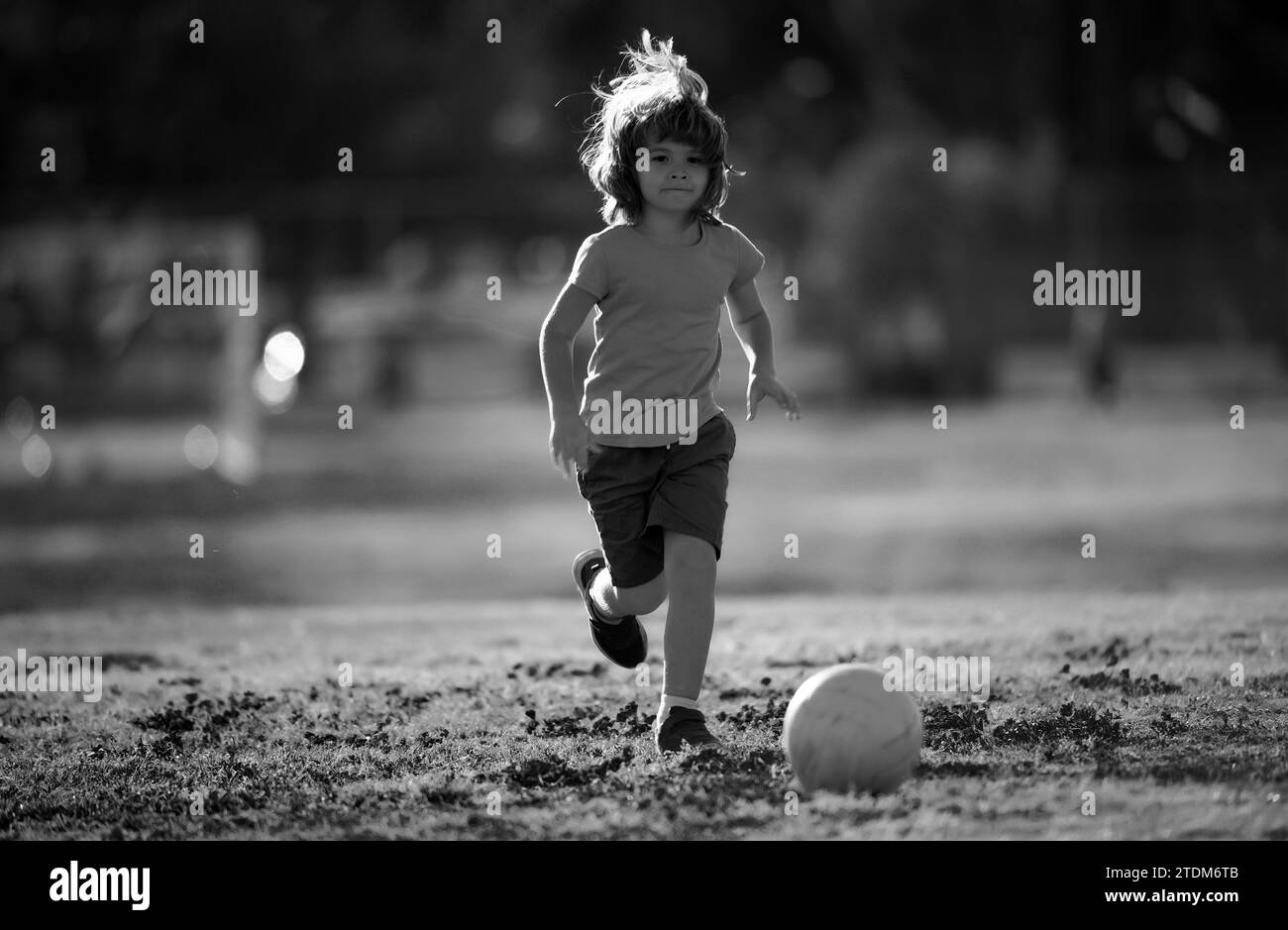 Boy child playing football on football field. Kid playing soccer ...