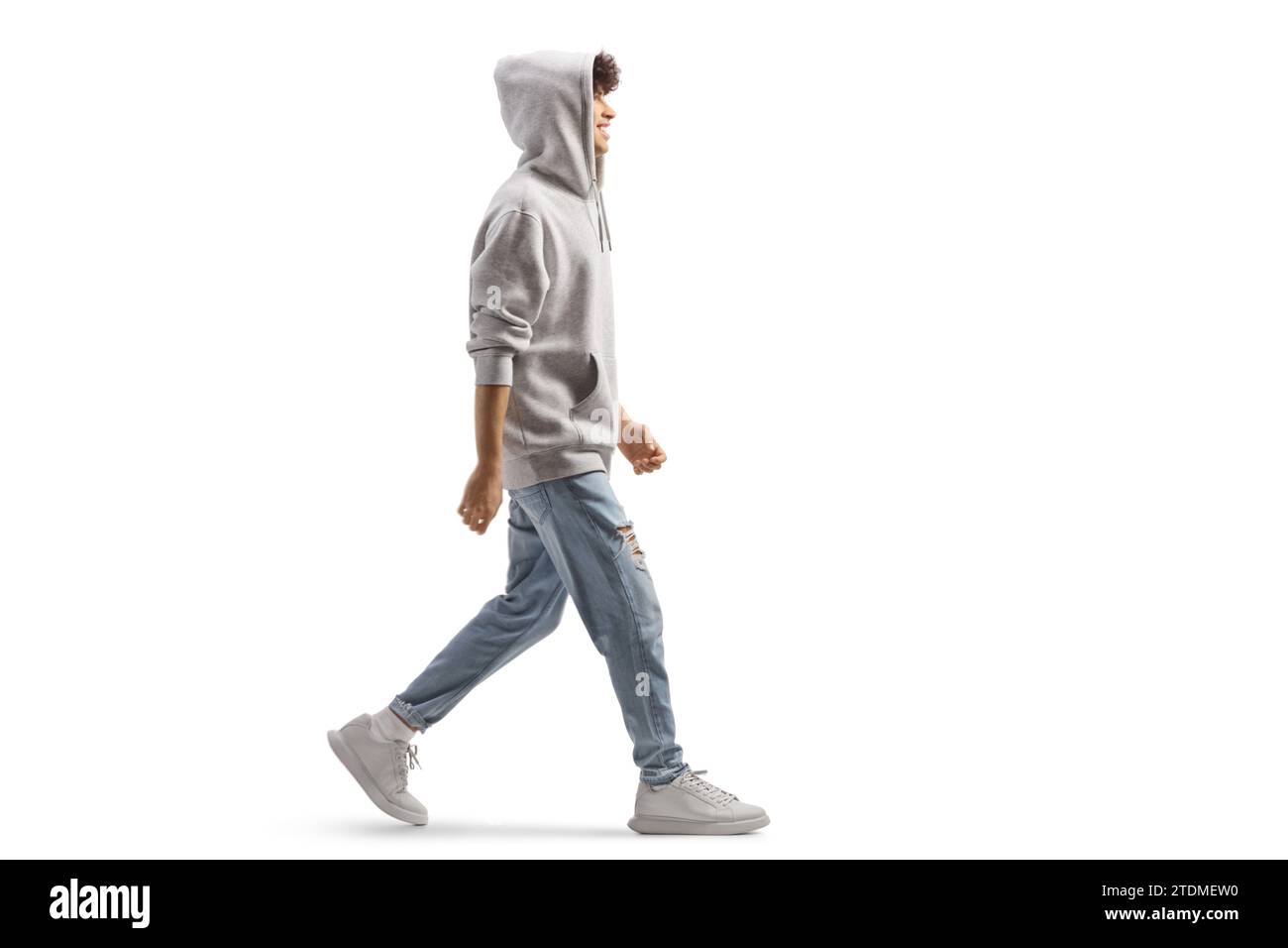 Full length shot of a tall guy wearing a gray hoodie and walking ...