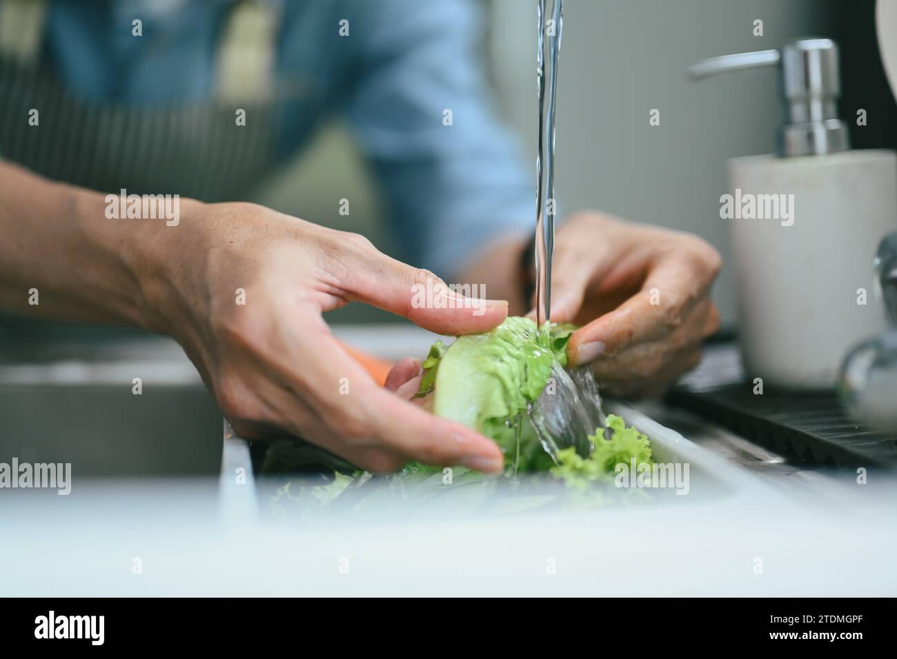 Closeup hands washing vegetables in the kitchen sink and preparing ...