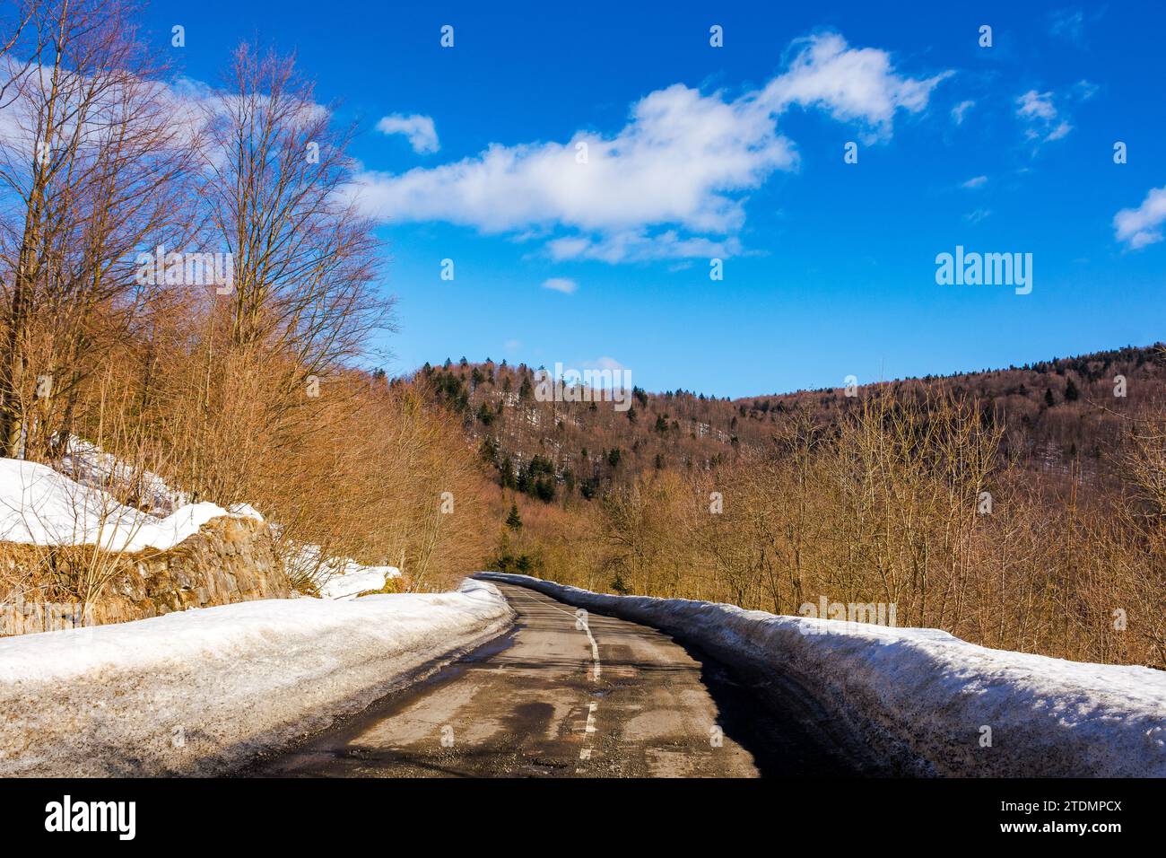 old road pass through snow covered hills. mountainous winter landscape ...