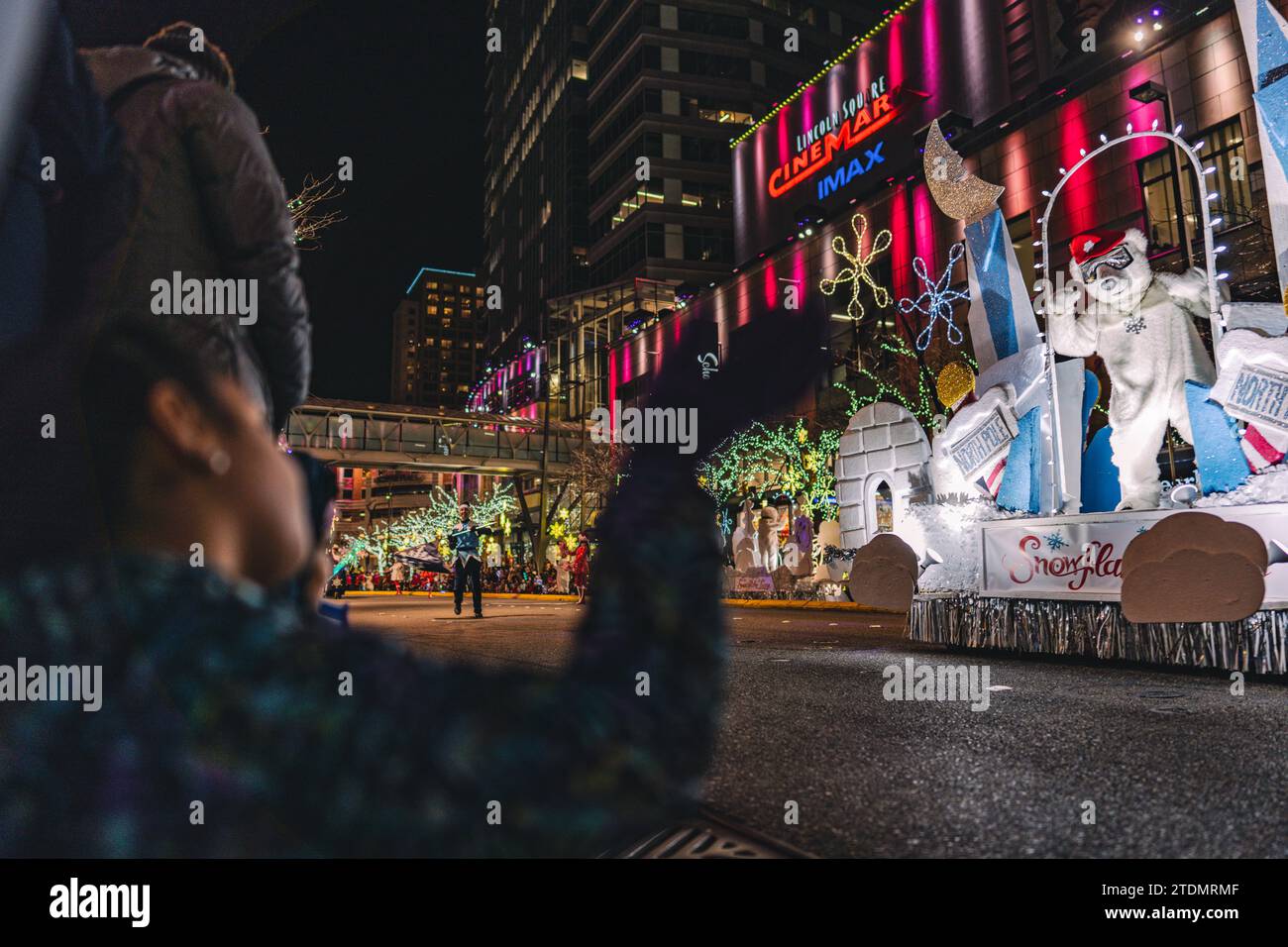 People watch the parade on the street. Nearly a thousand people ...