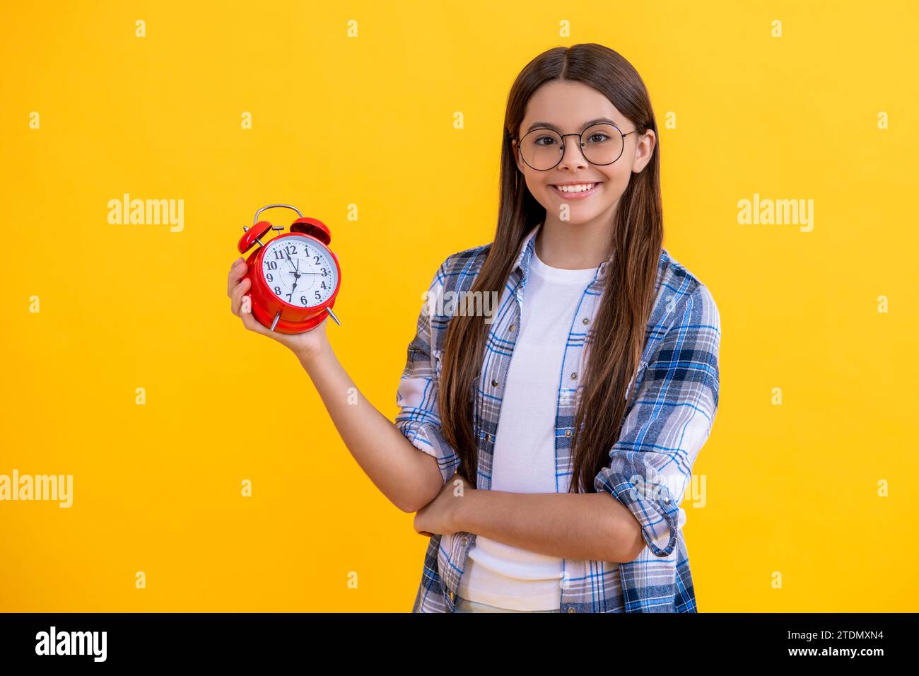 Teen girl hold alarm clock. school time. Teen girl checking the clock ...